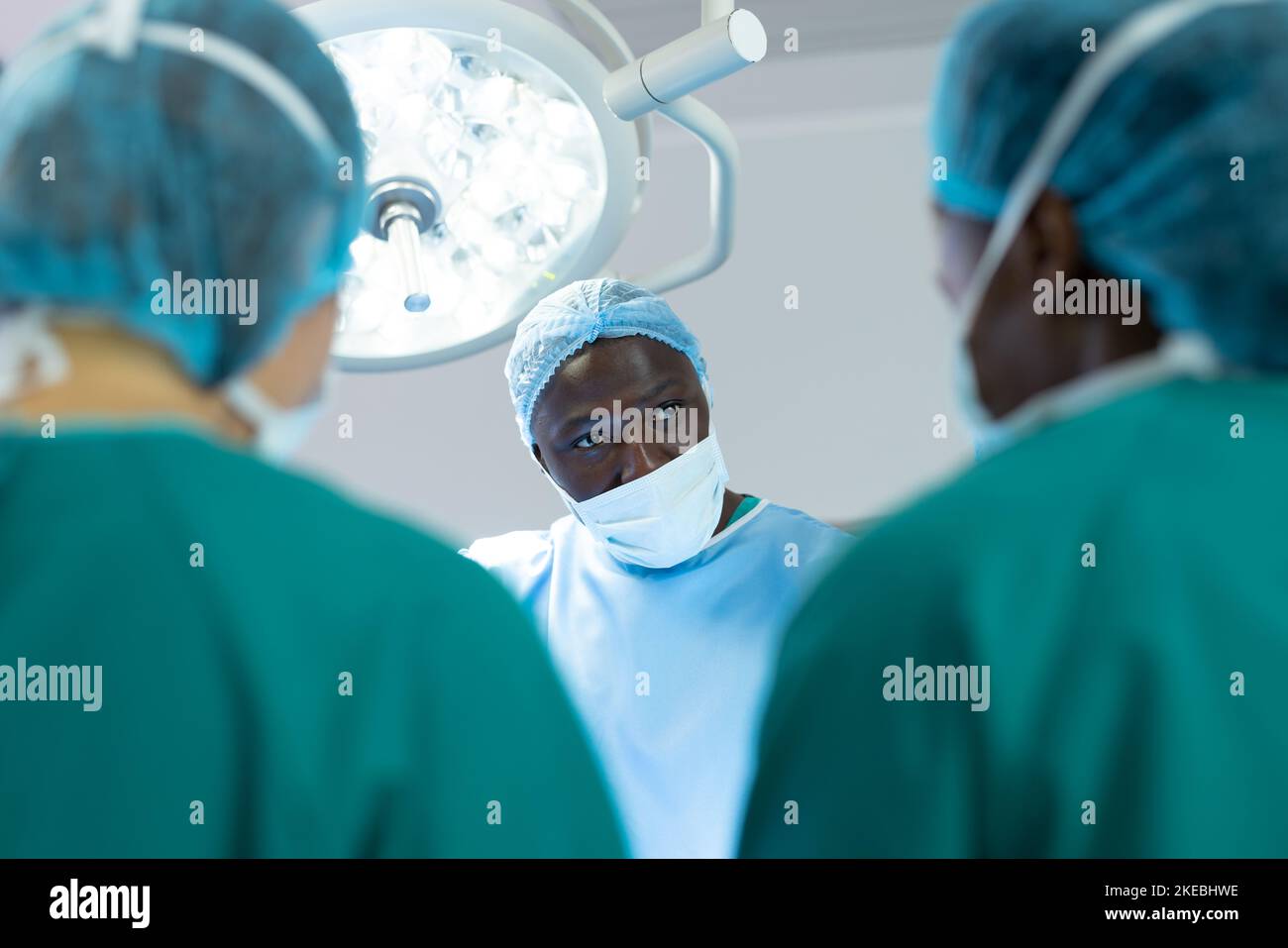 African american male surgeon talking with colleagues in theatre during ...