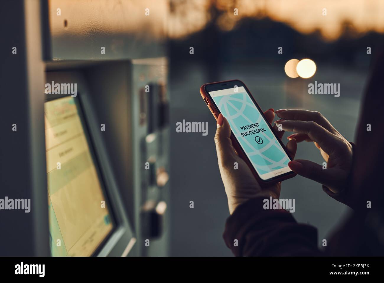 Woman buying ticket at ticket machine paying using mobile payment app ...