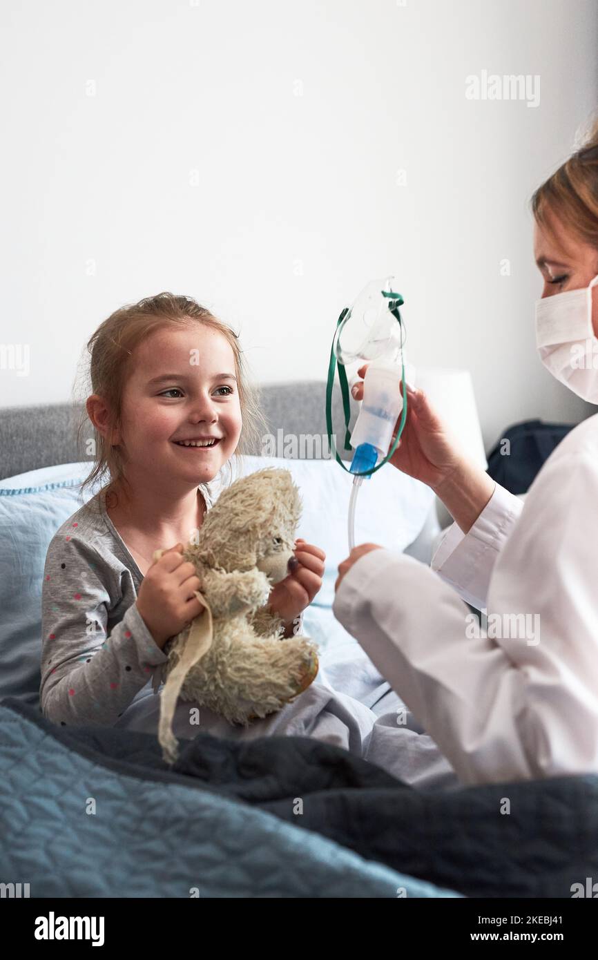 Doctor visiting little patient at home. Child having medical inhalation ...