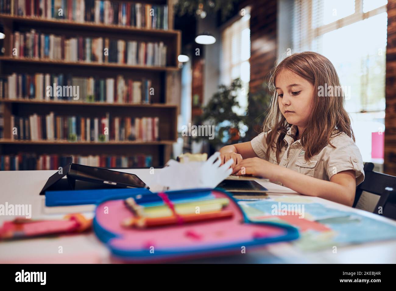Schoolgirl learning, playing, doing puzzles and reading book in school ...