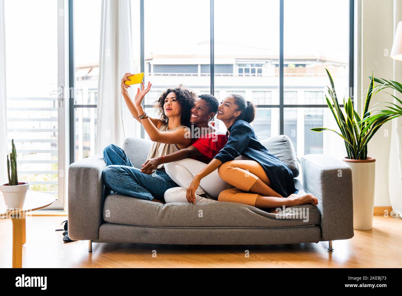 Happy beautiful hispanic south american and black women meeting indoors ...