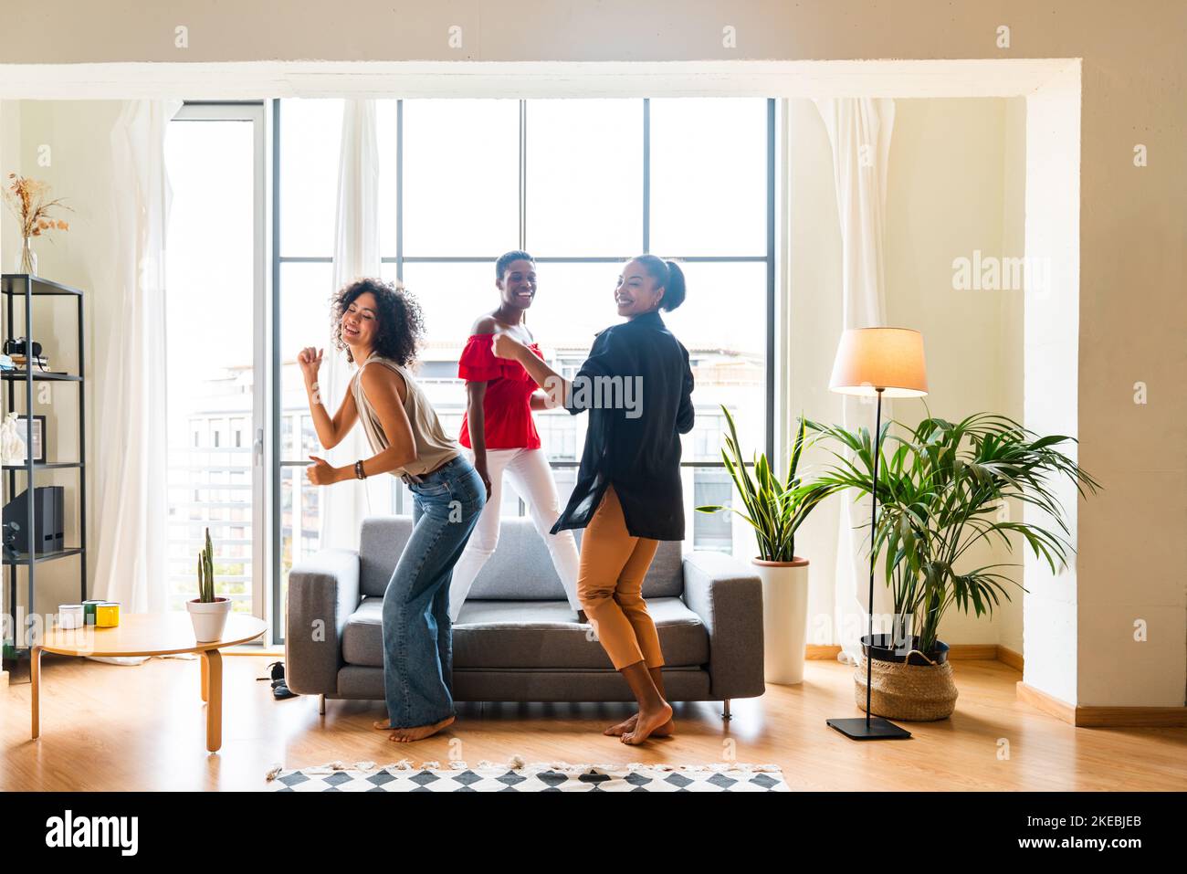 Happy beautiful hispanic south american and black women meeting indoors ...