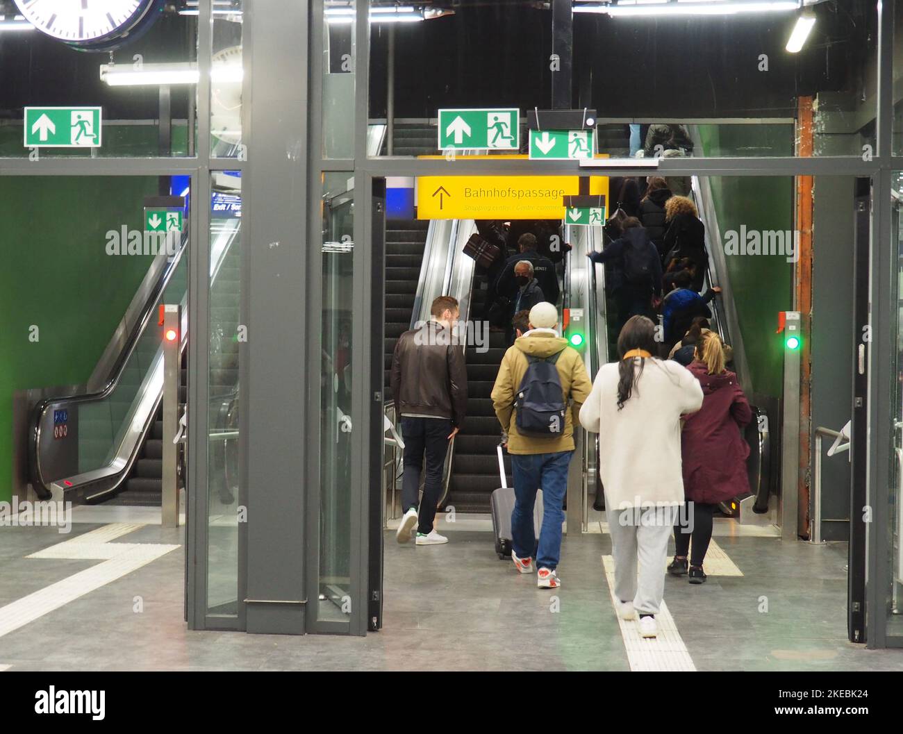 The view of people taking the escalator - emergency exit arrows in a ...
