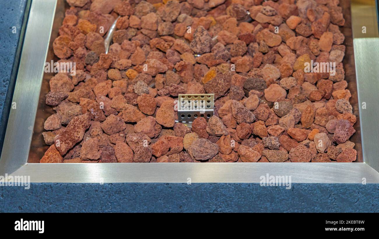 Gas Burner With Decorative Red Lava Rocks Home Heating Stock Photo - Alamy
