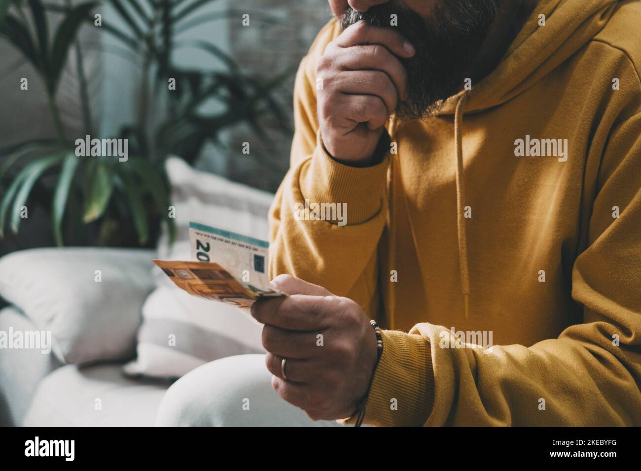 Close up portrait of man holding cash money banknotes with worried ...