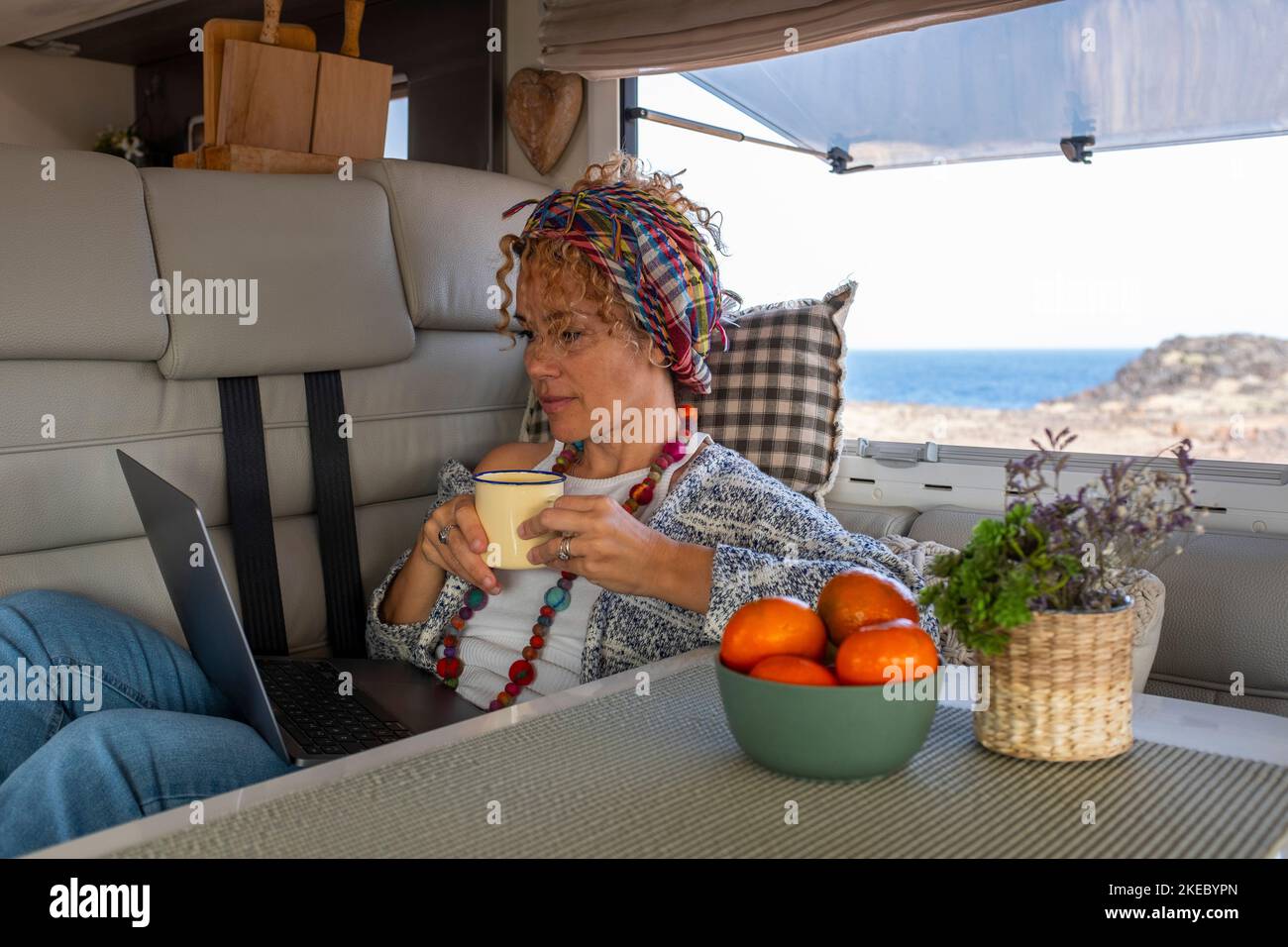One independent woman laying and working inside a camper van with ...
