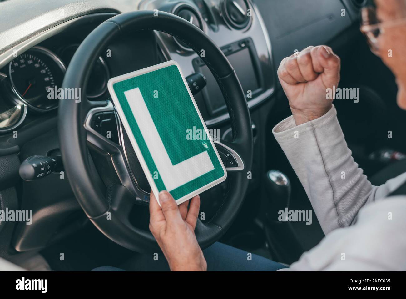 One old woman getting the pass to drive a car at mature age. Senior ...