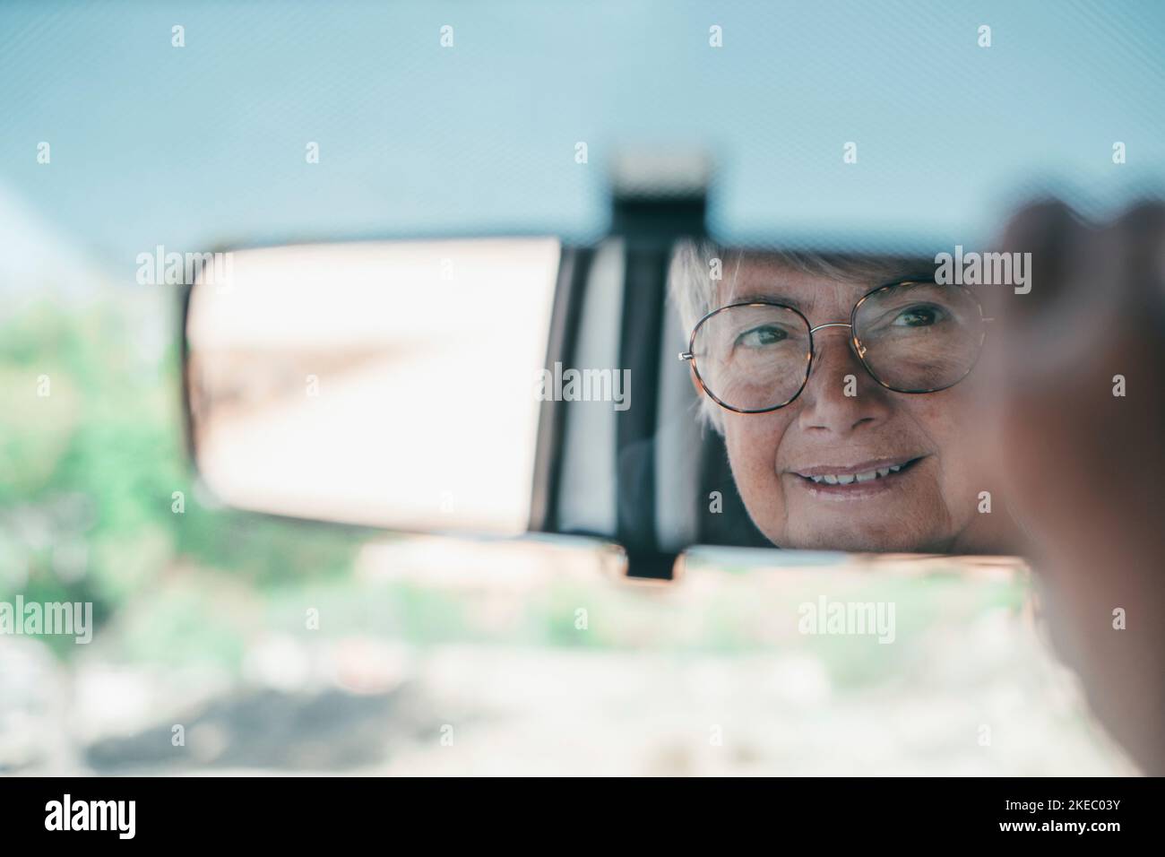 Close up of one old woman looking at the road while driving. Back ...