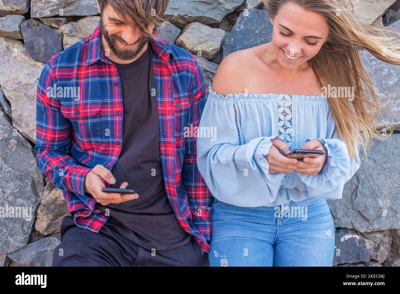 couple of two adults using their phones together outdoors - technology ...
