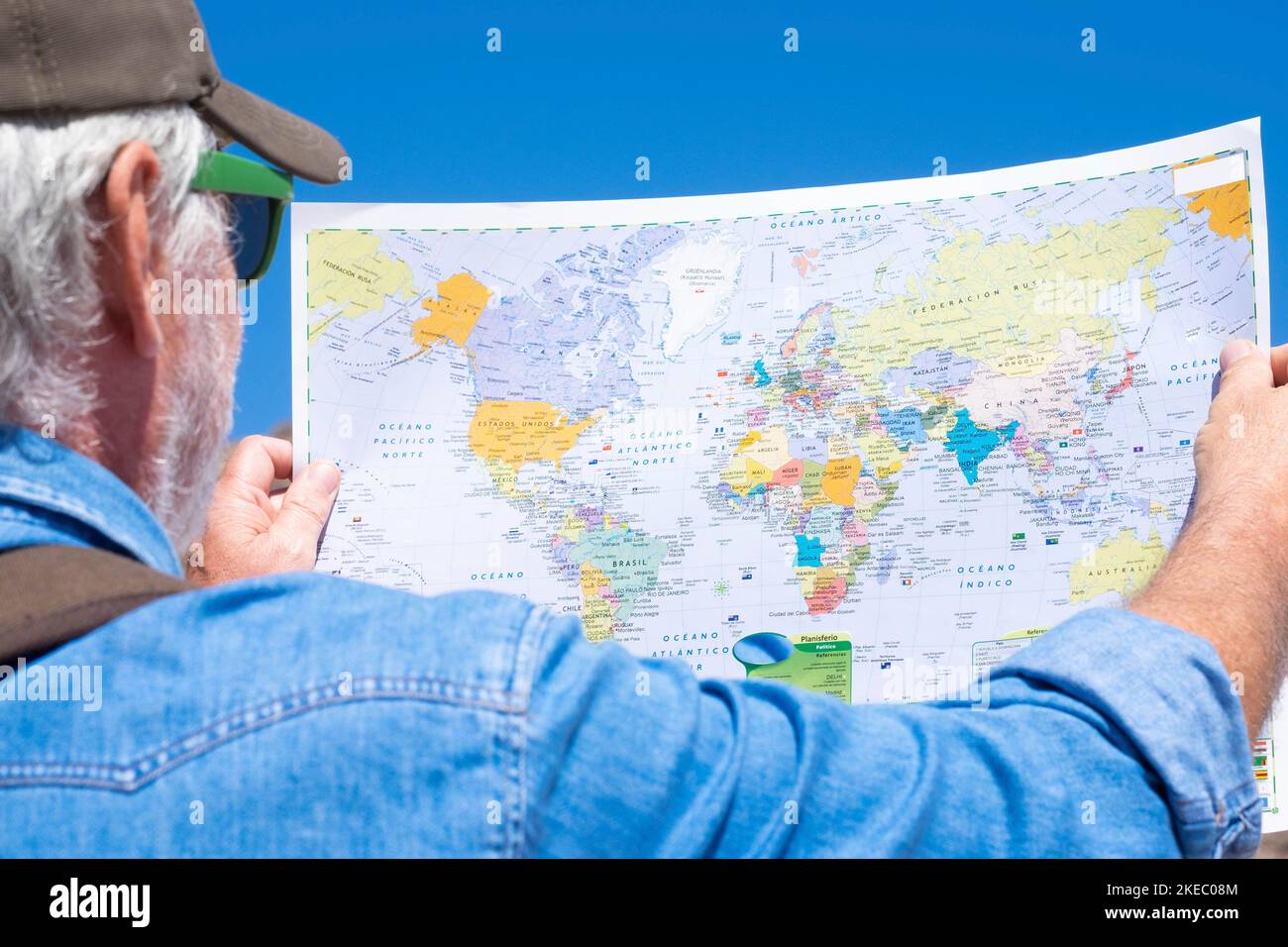 close up of mature man holding a map in his hands and looking at it to ...