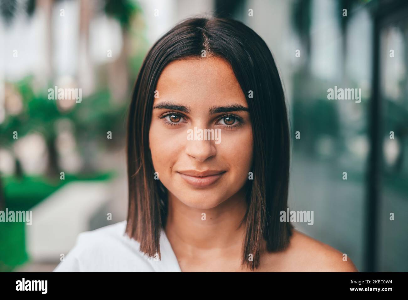 Happy young fashionable woman with short hair looking at camera ...