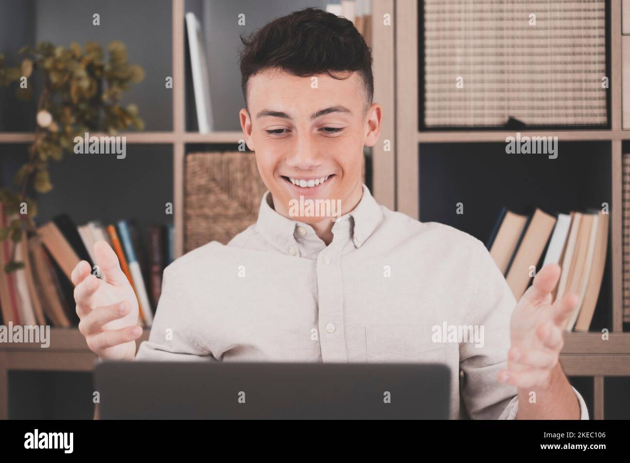 Happy young man teenager smiling and talking in video conference ...