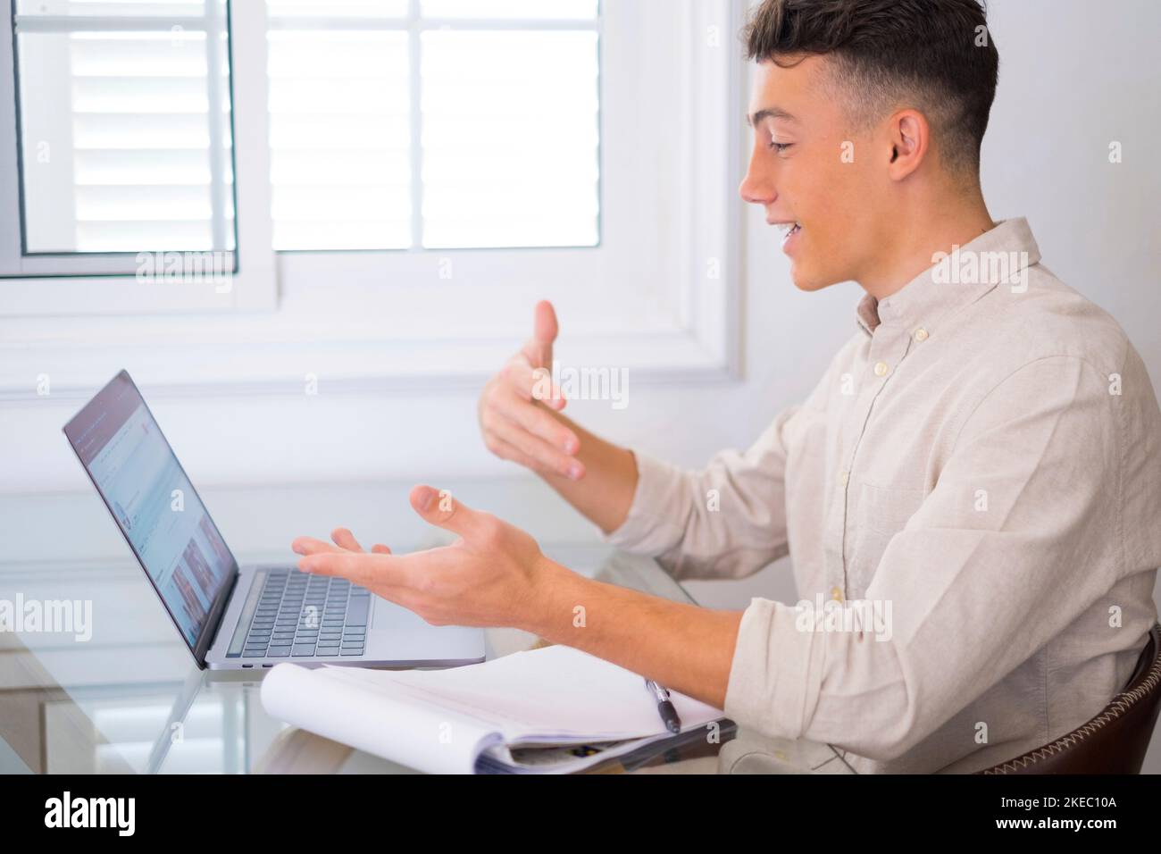 Happy young man teenager smiling and talking in video conference ...