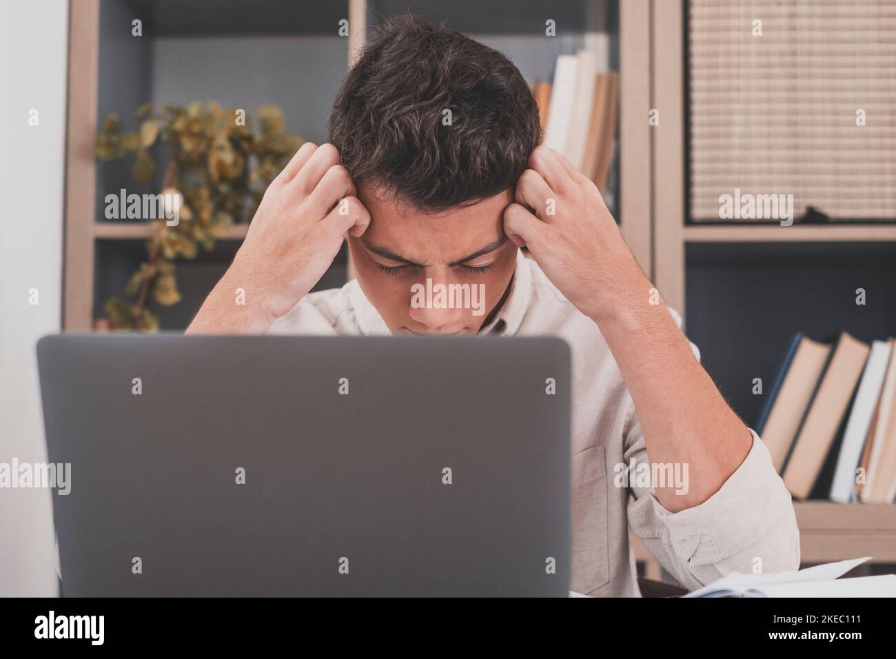 Unhealthy stressed young man suffering headache at home because ...