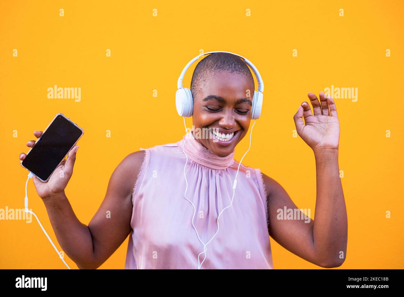 happy african or american woman dancing and vibing alone with her phone ...