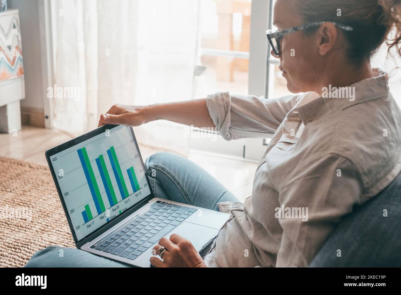 Close up rear view young woman using laptop and calculator, working on ...