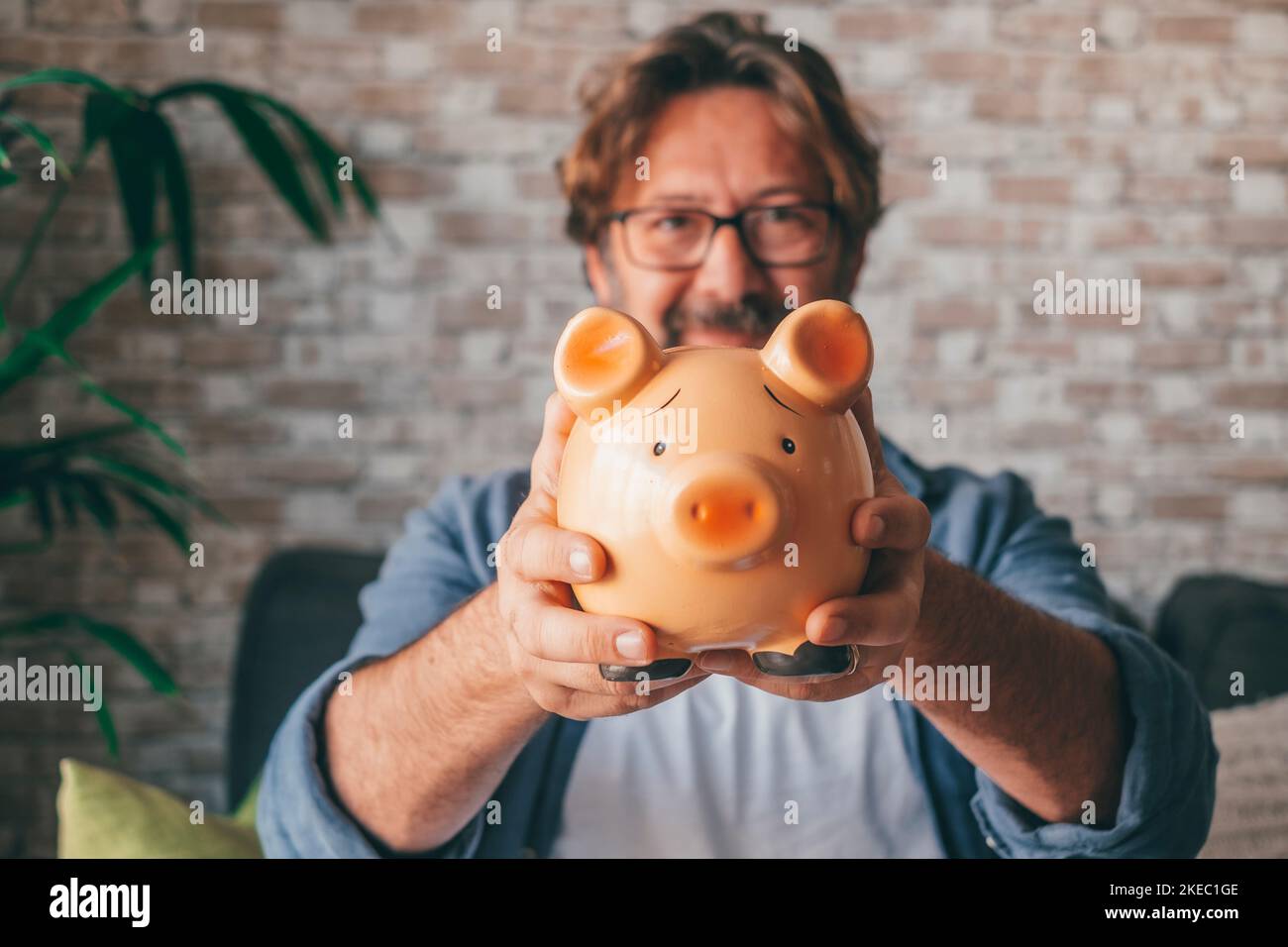 Happy mature man showing piggy bank to save money. Caucasian male ...
