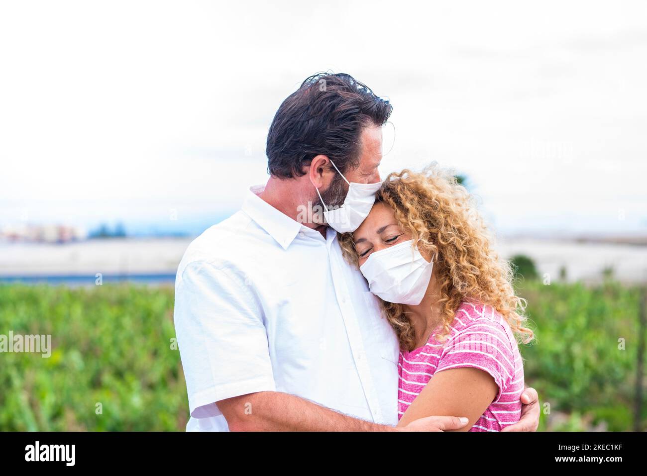 couple of people hugged together and man giving a kiss at his wife ...