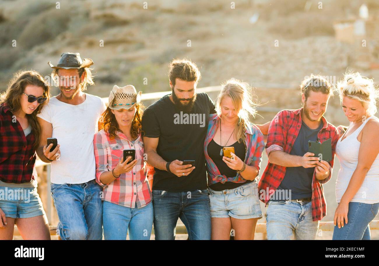 group of seven people together using their phones and having fun ...