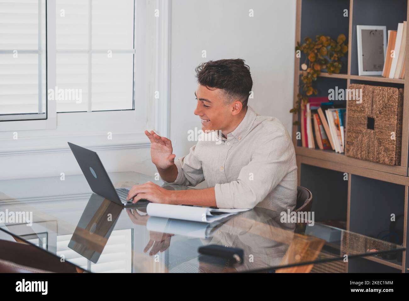 Happy young man teenager smiling and talking in video conference ...