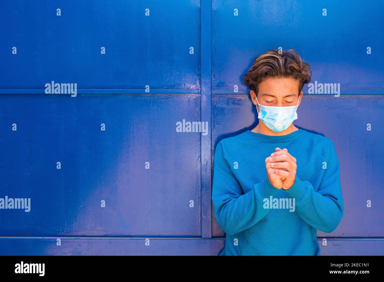portrait and closeup of man teenager praying and wearing medical and ...