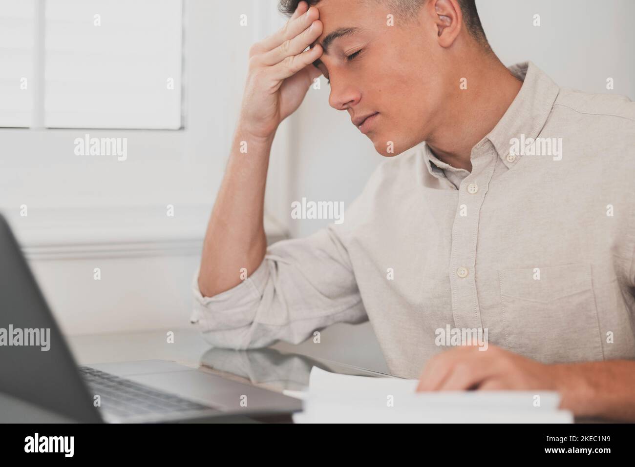 Unhealthy stressed young man suffering headache at home because ...