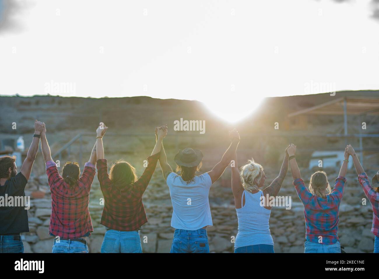 group of seven people holding their hands together up and looking at ...