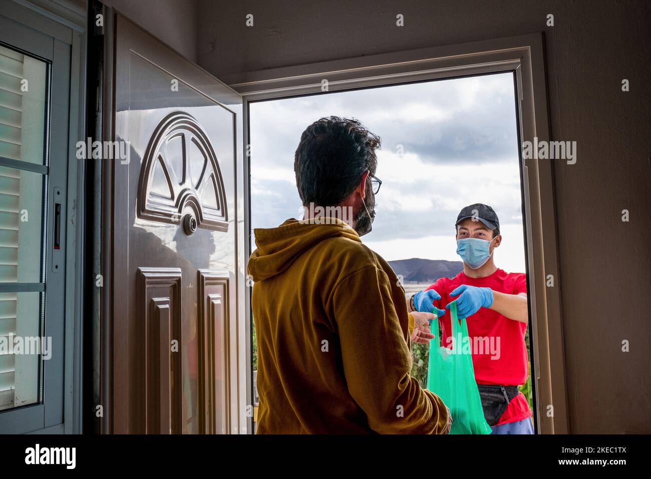 one old man taking and paying for his foos delivery at home in quarantine and lockdown time for ...