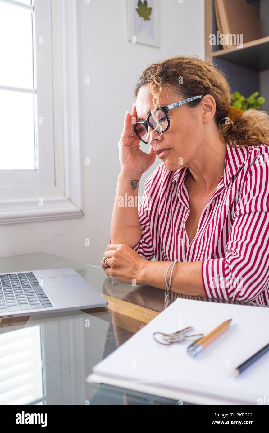 Exhausted female executive holding head in hand feeling lack of energy ...