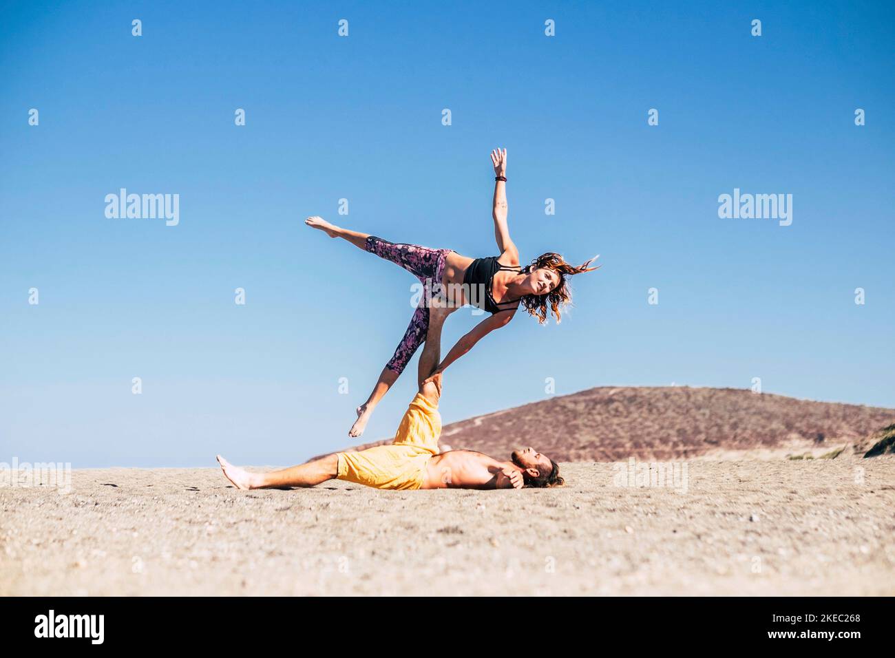 couple of two active and fitness adults doing acro yoga together at the ...