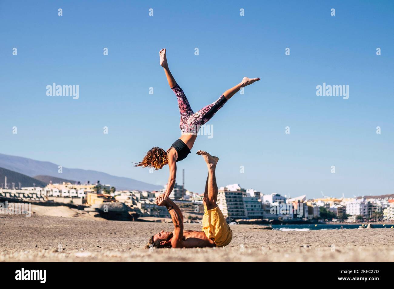 couple of two active and fitness adults doing acro yoga together at the ...