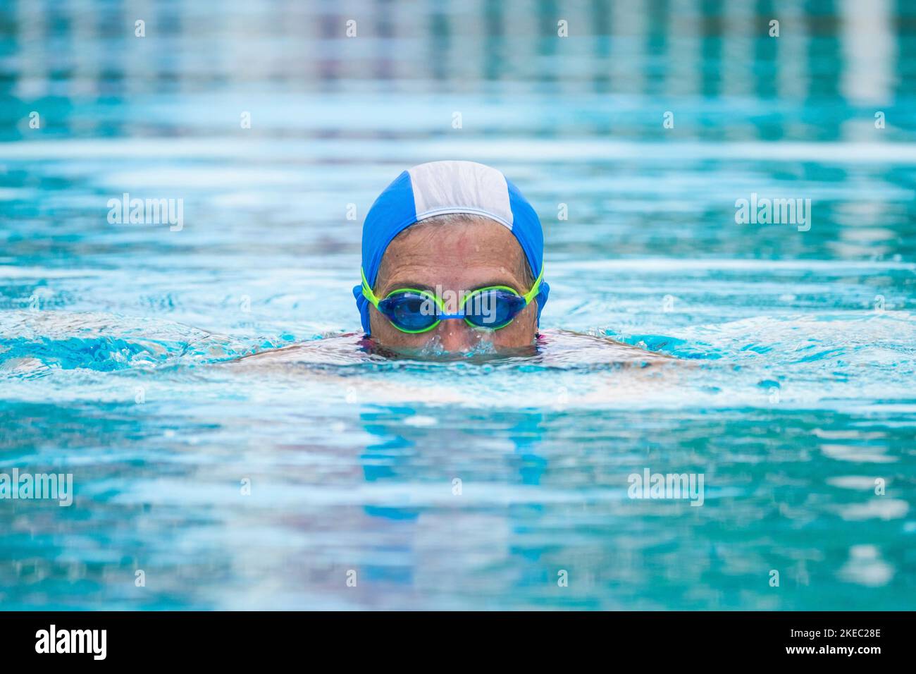 close up of mature woman swimming in a pool alone - portrait of active ...