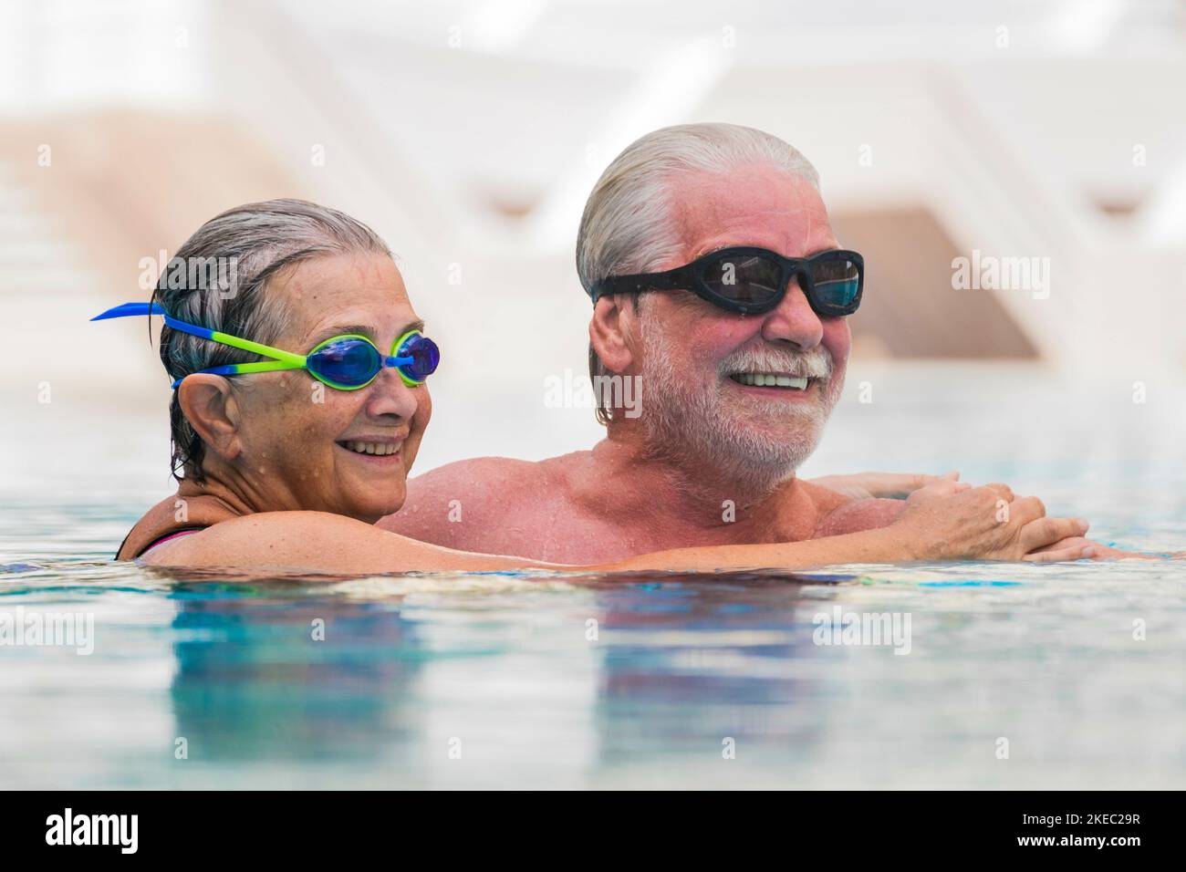beautiful couple of two seniors together at the swimming pool having ...