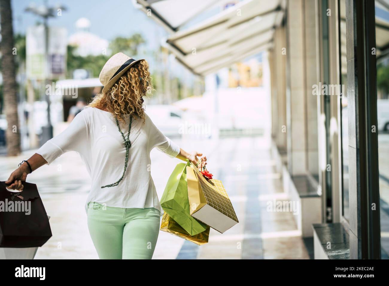 one beautiful woman with shopping bags doing shopping in a mall alone ...