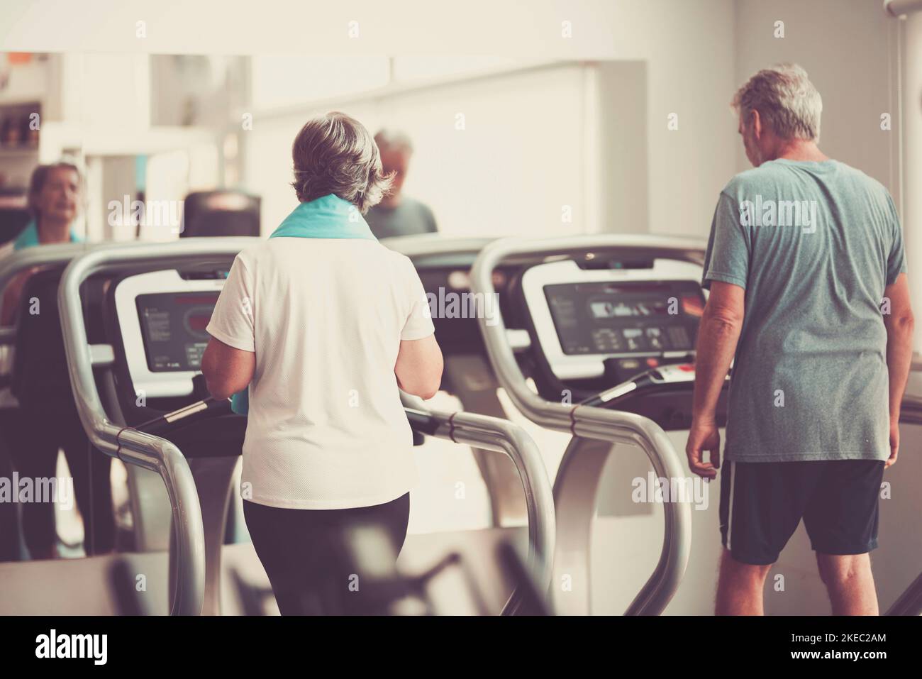 couple of two active seniros doing exercise together at the gym ...