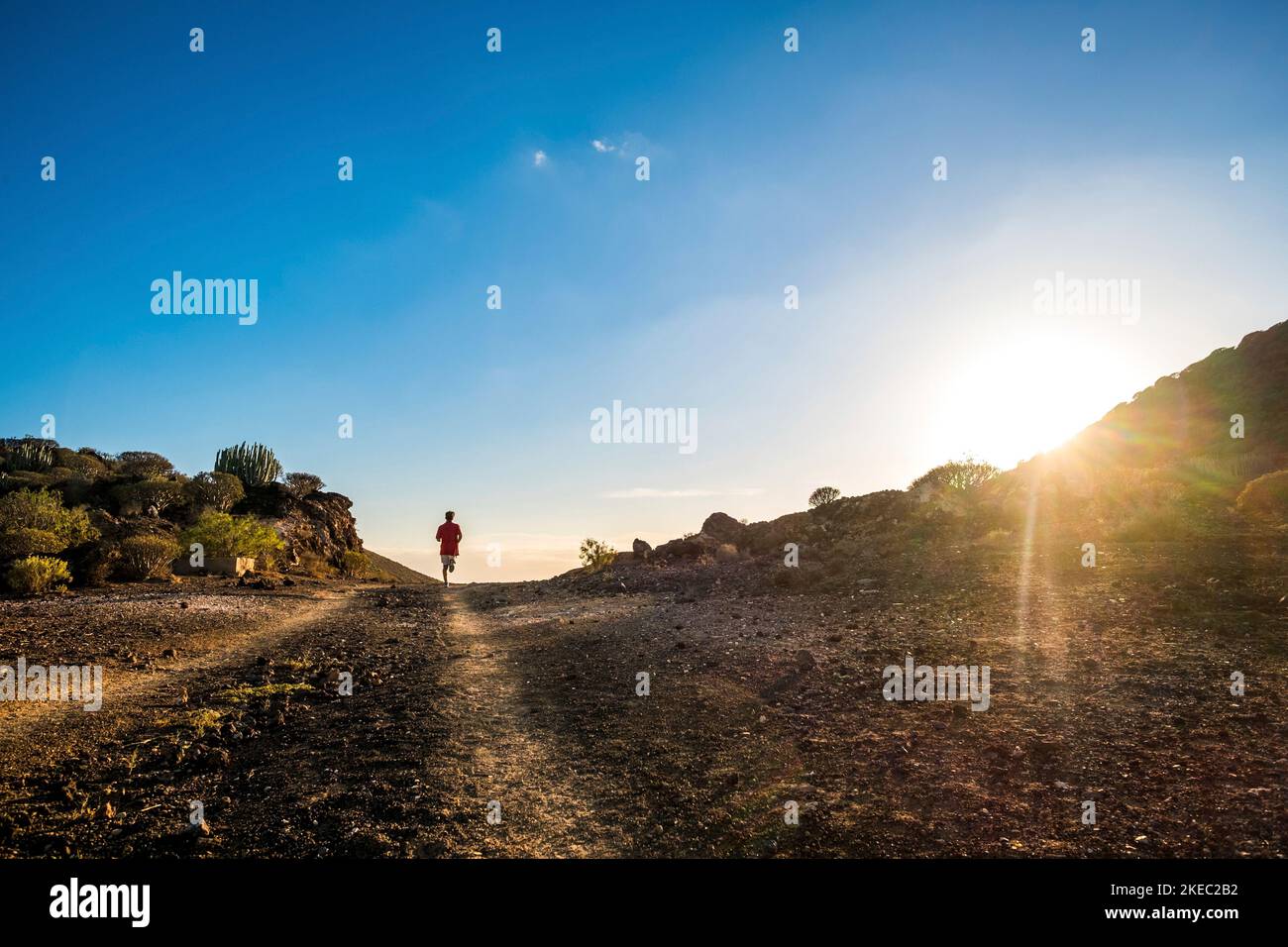 one young man running alone in the mountain at the sunset to be fitness ...