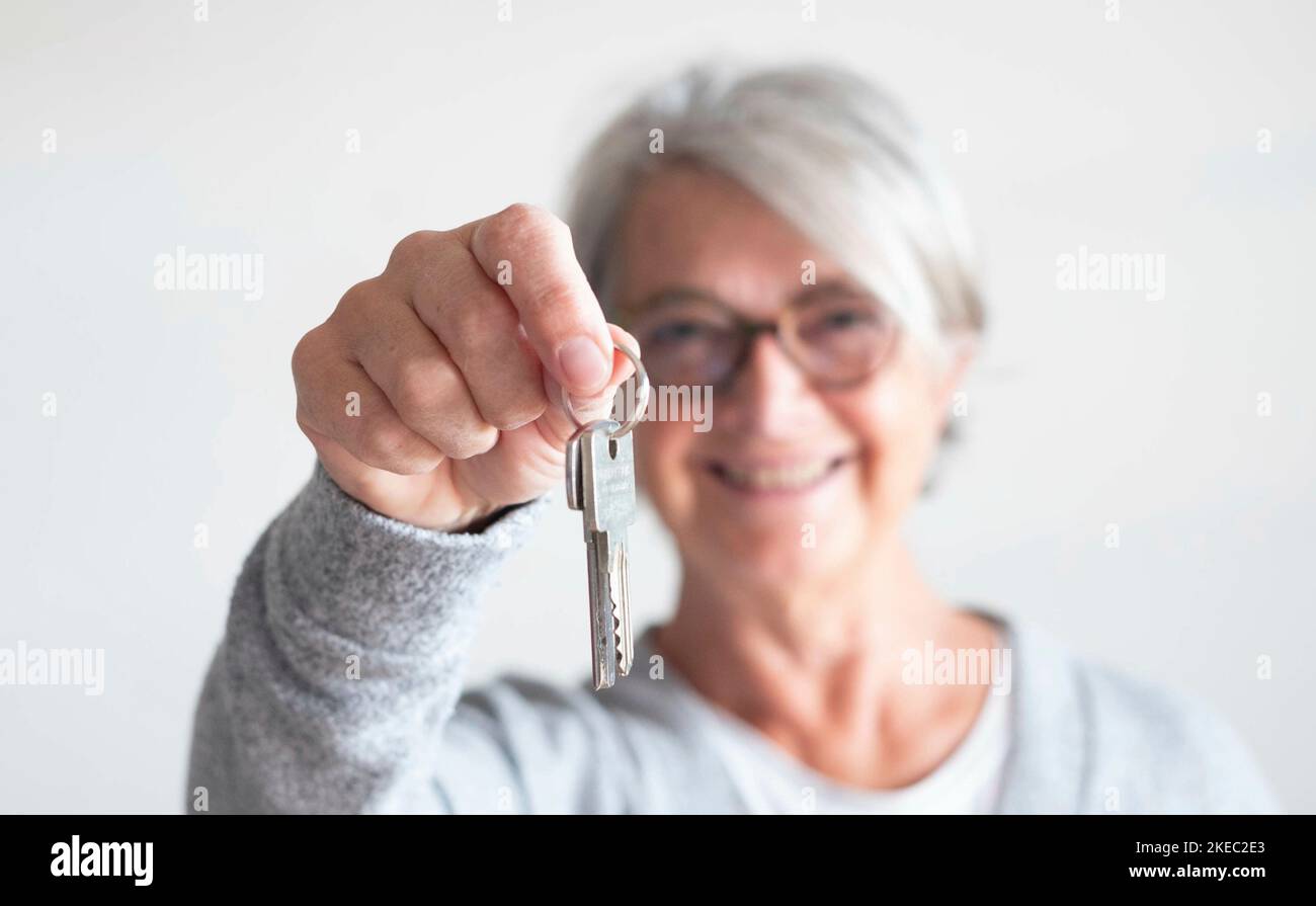 close up of mature woman holding a couple of keys of her new house or ...