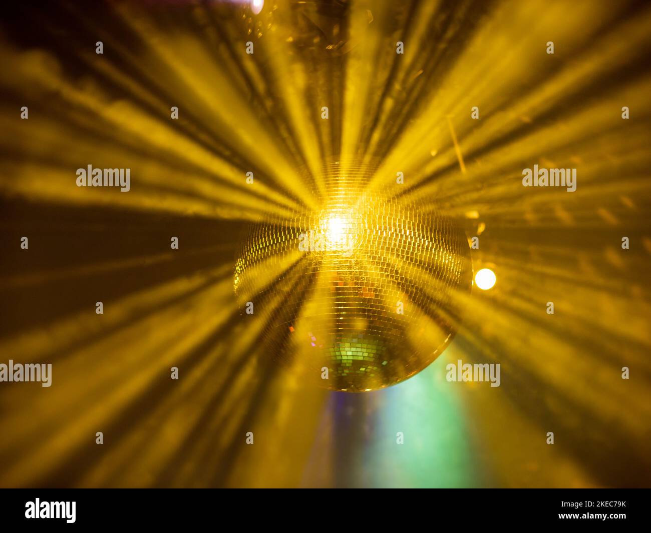 Disco ball reflecting golden light at a party location. Bright light ...