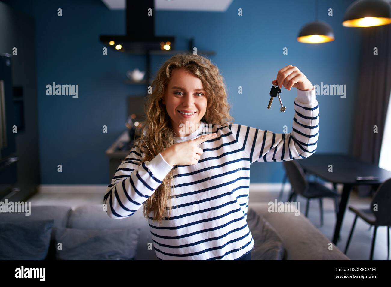Happy woman showing new house or apartment keys to camera in modern ...