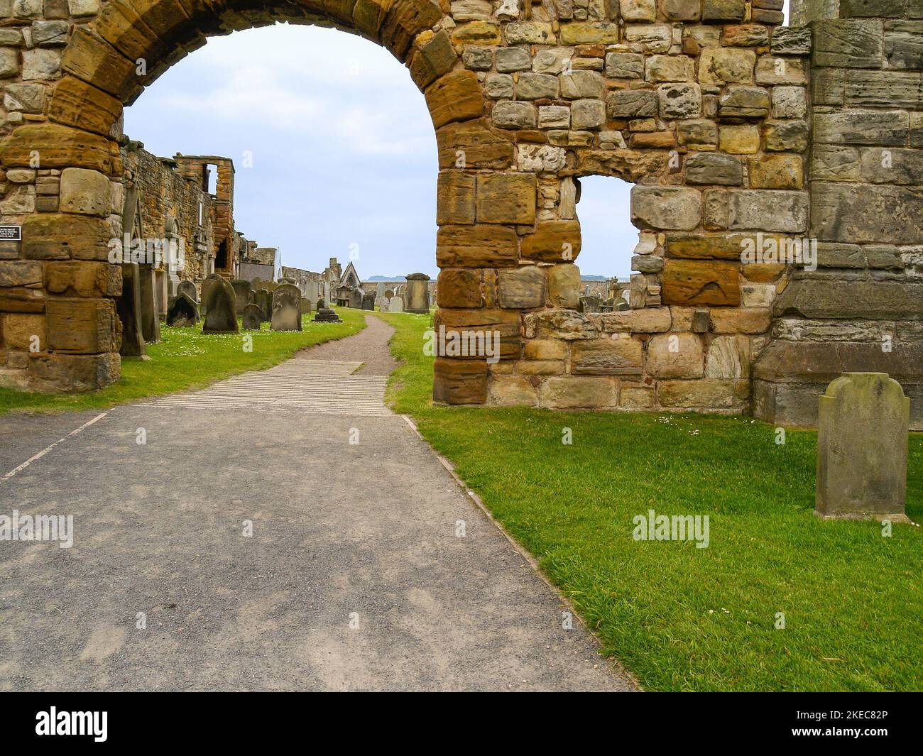 Path under stone arch in perimeter wall of graveyard at St Andrews ...