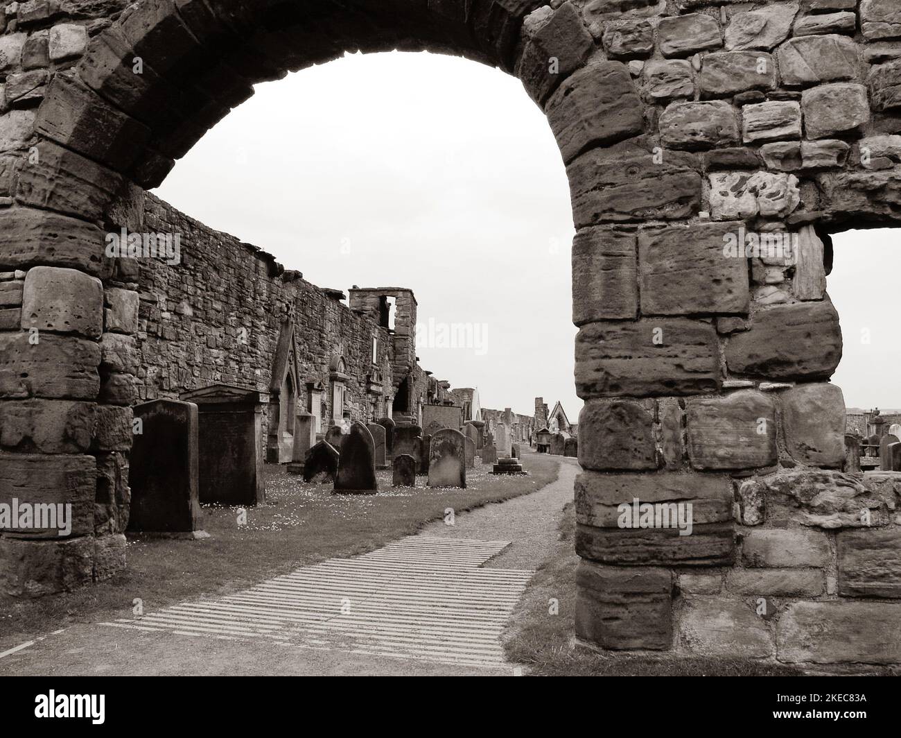 Path under stone arch in perimeter wall of graveyard at St Andrews ...