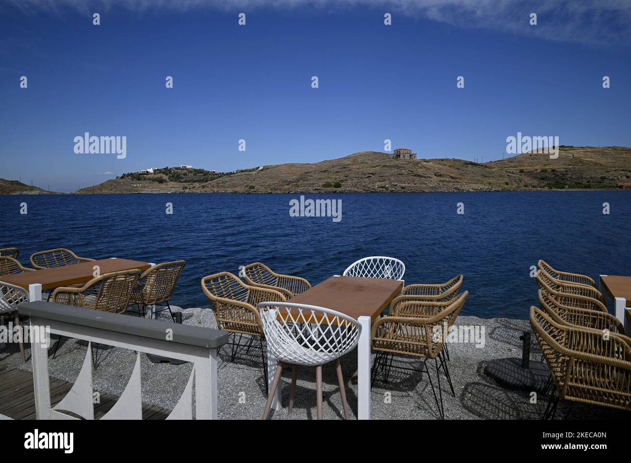Seascape with scenic view of a traditional Greek cafe rattan furniture ...