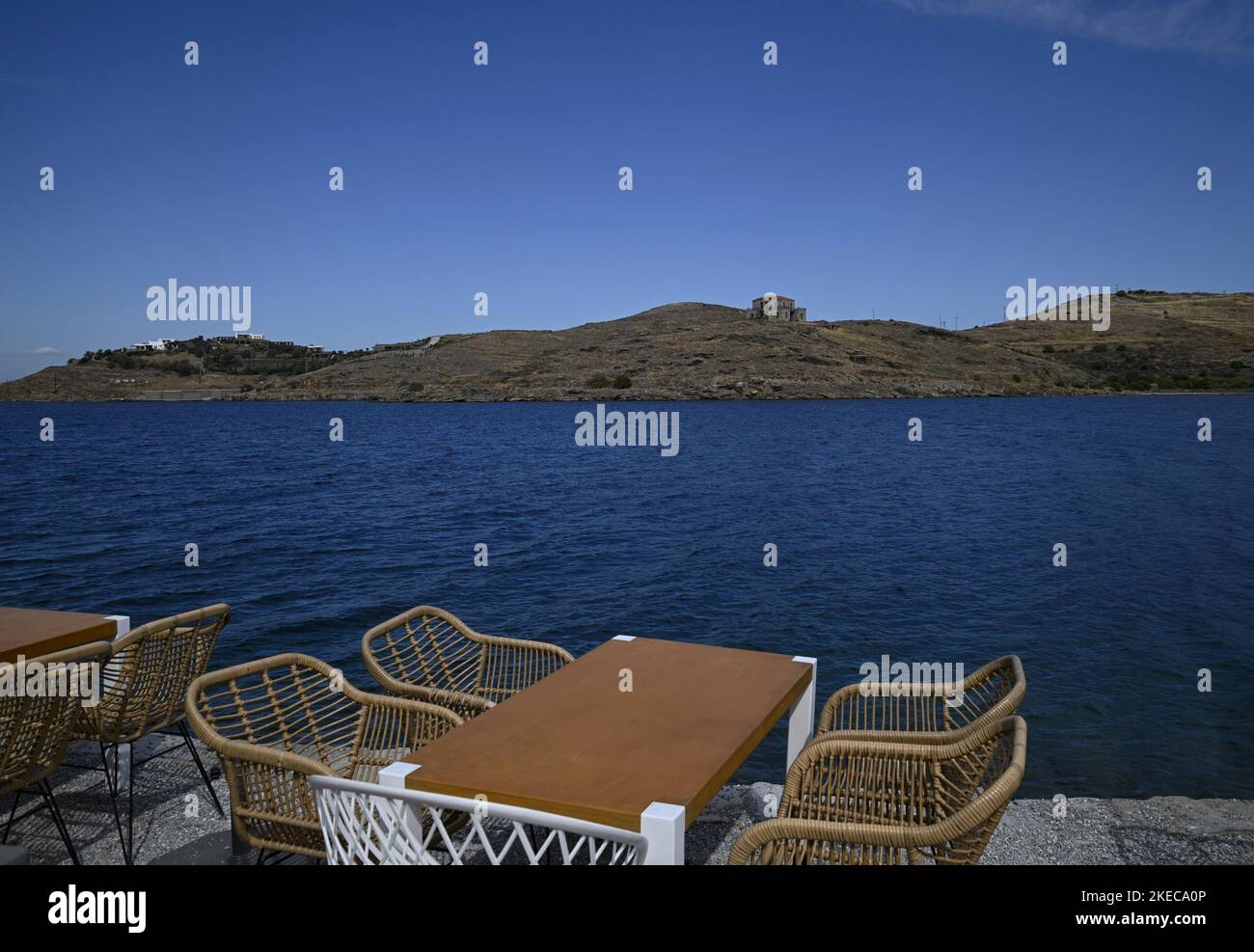 Seascape with scenic view of a traditional Greek cafe rattan furniture ...