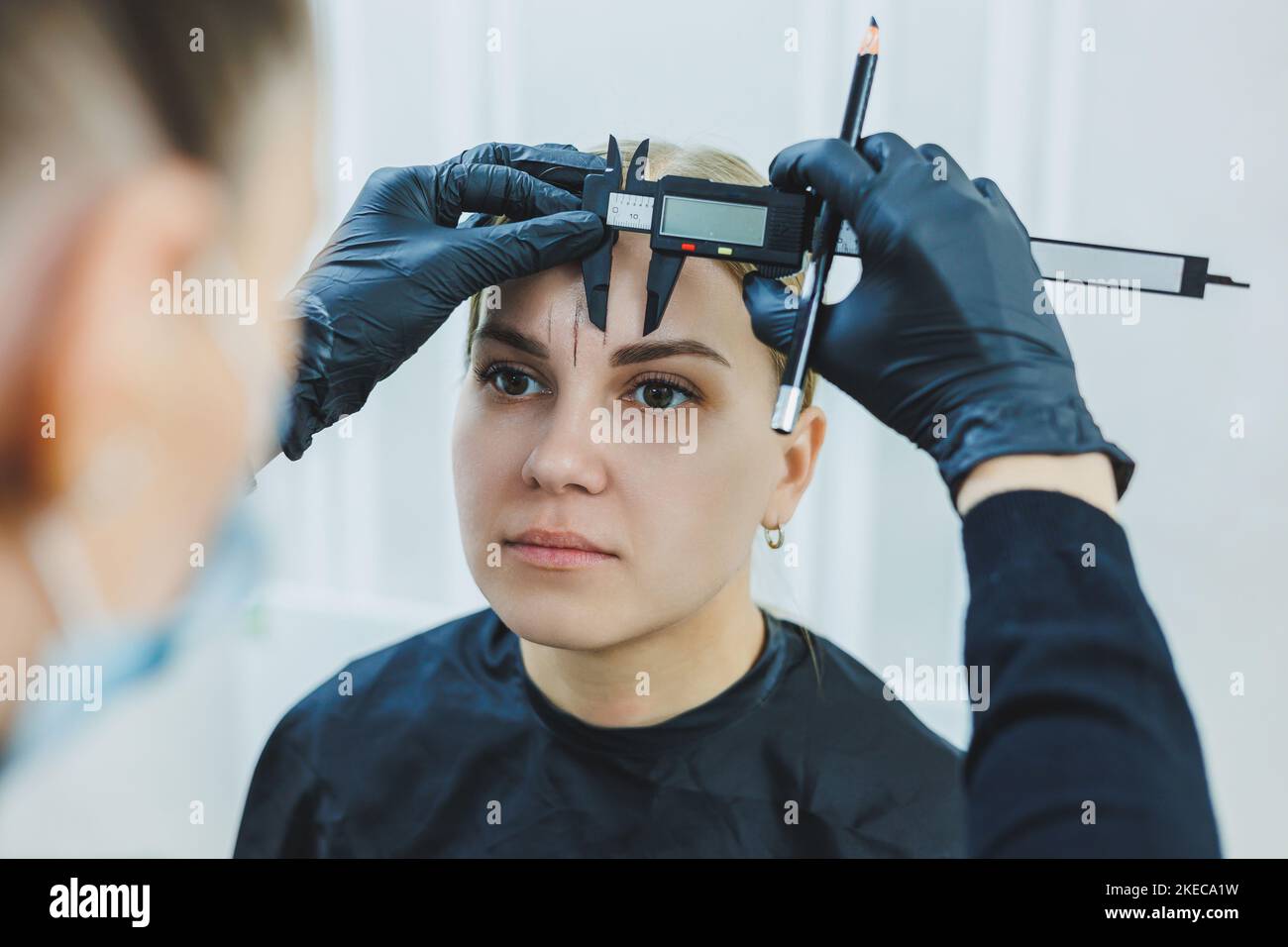 permanent eyebrows tattoo. permanent tattoo master checks the distance ...