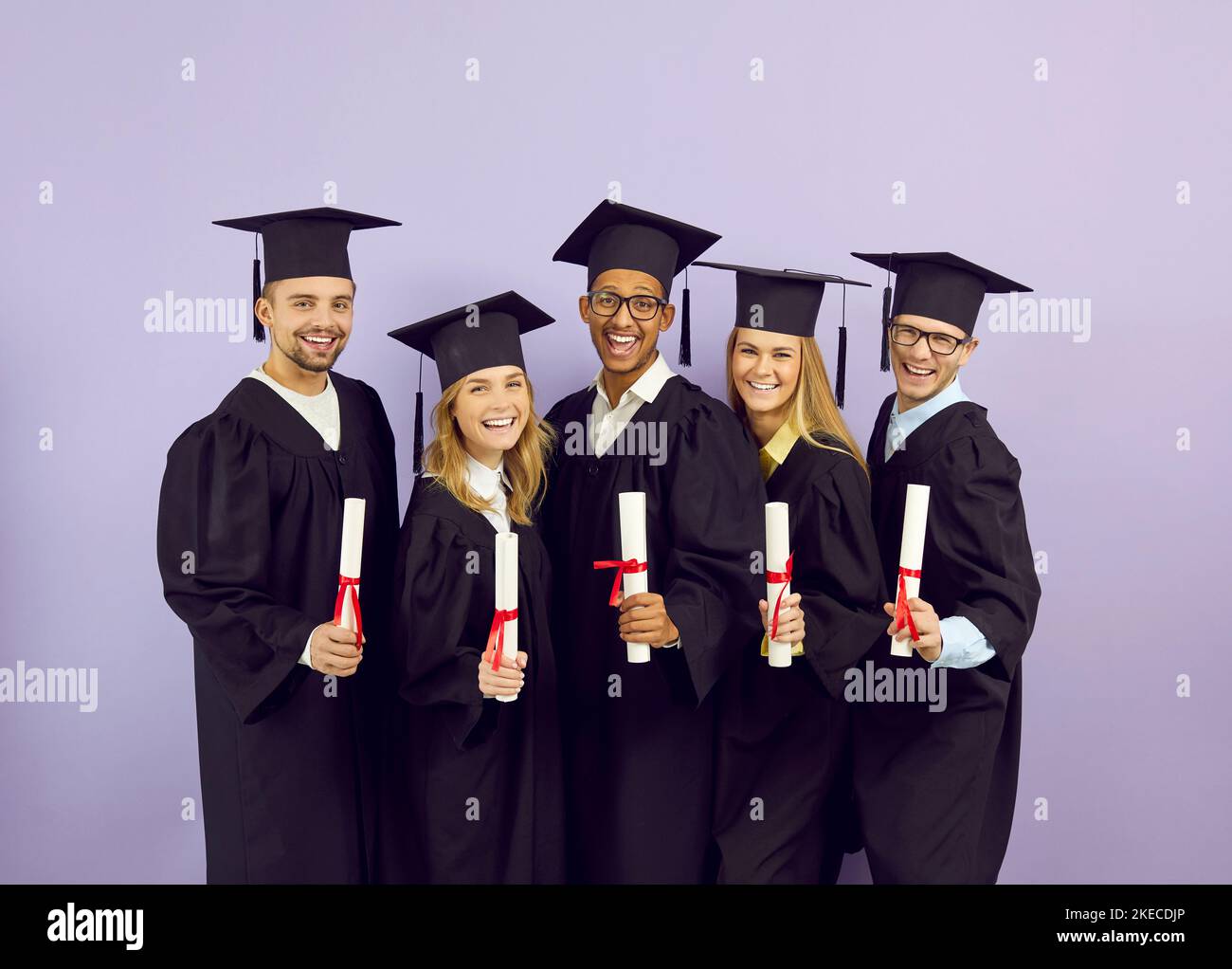 Portrait of group of happy graduates in academic mantles holding ...