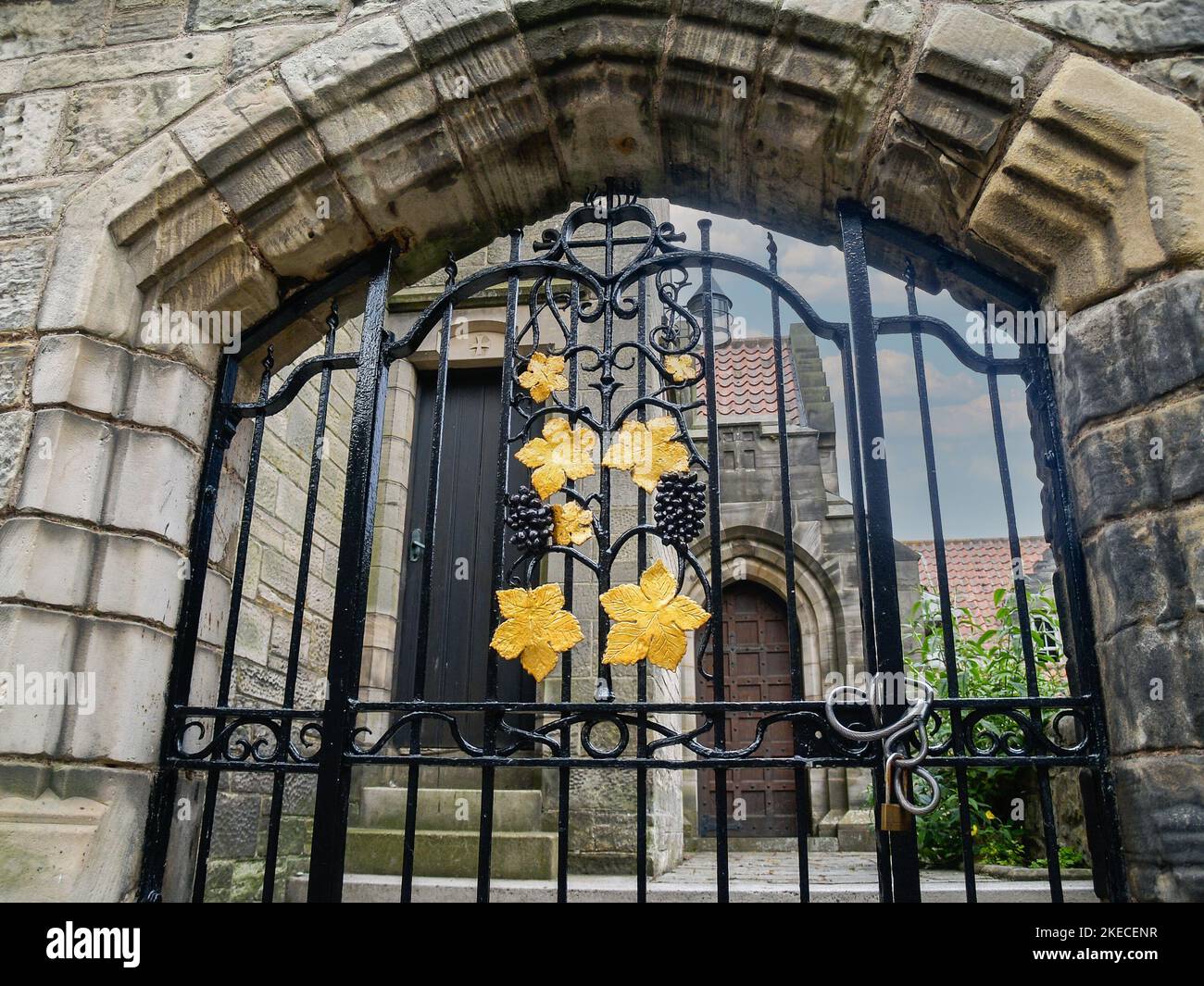 Wrought iron gates with grape vine and golden leaves in entrance to ...