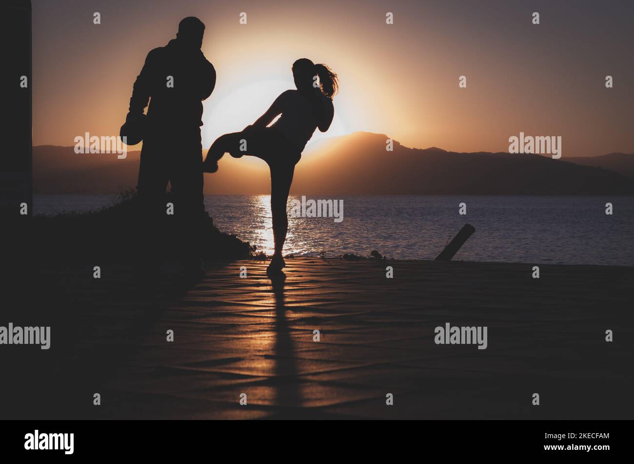 The silhouettes of a man and a woman on the beach fighting with each ...