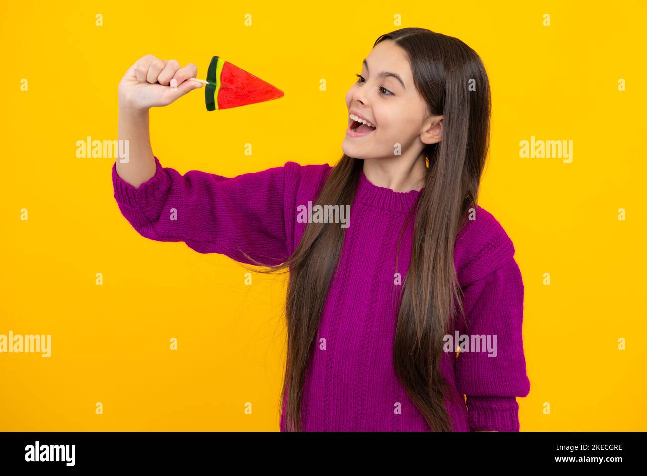 Funny child with lollipop over yellow isolated background. Sweet ...
