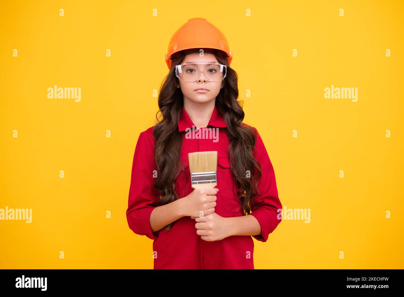 Child builder in hard hat helmet. Teenage girl painter with painting ...