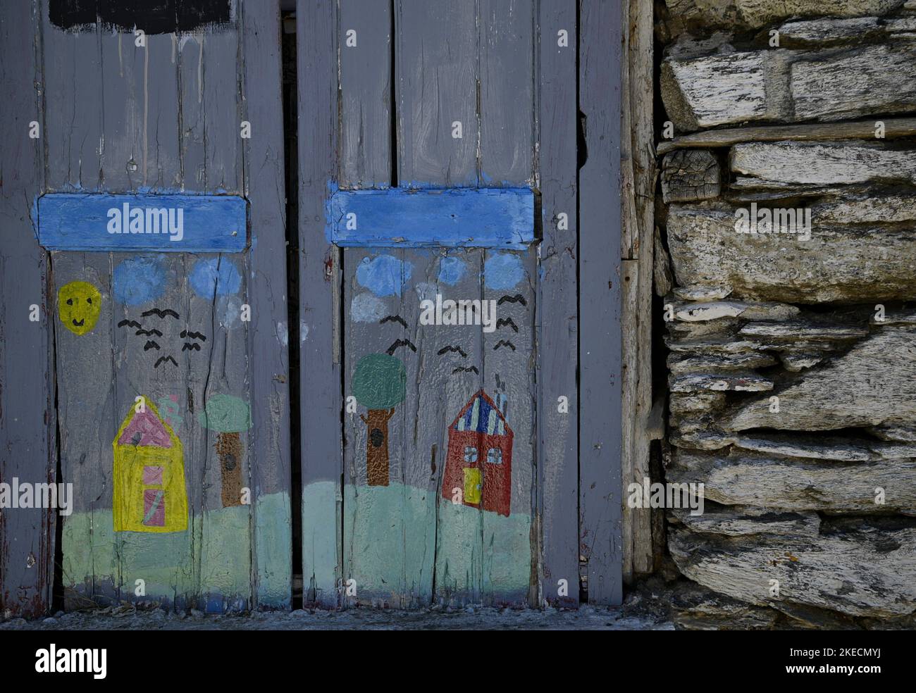 Traditional hand painted antique wooden window against a stone wall in ...